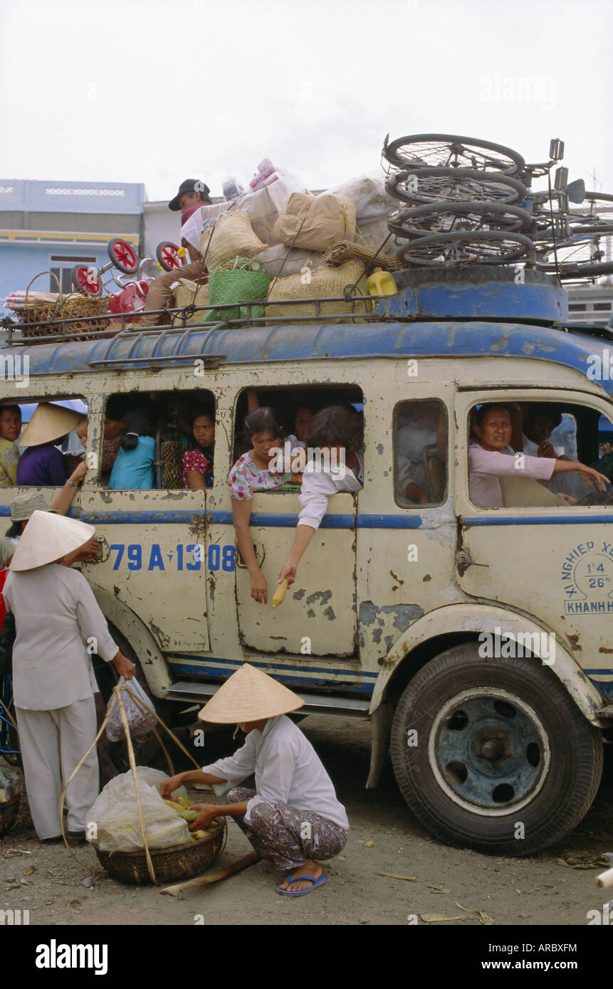 Crowded bus with bicycles, sacks and passengers on roof, city bus ...