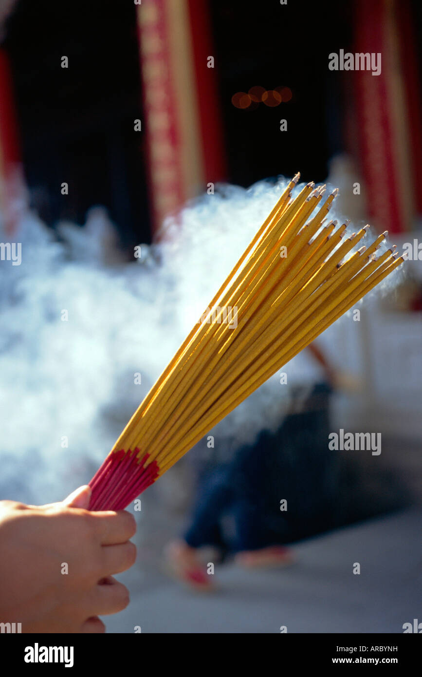 Hand holding smoking incense sticks in Hong Kong, Asia Stock Photo - Alamy