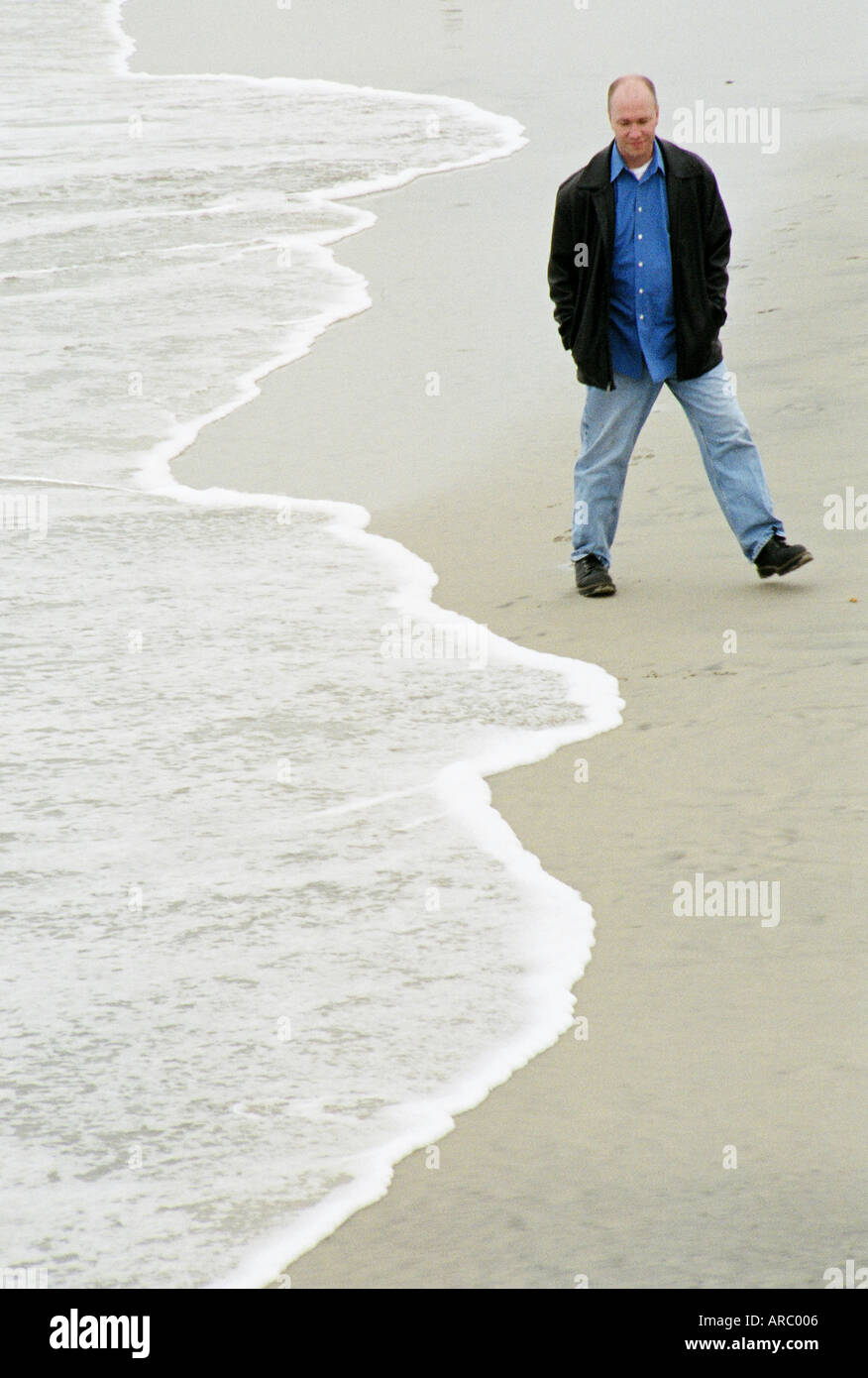 single man walkin on the beach Stock Photo - Alamy