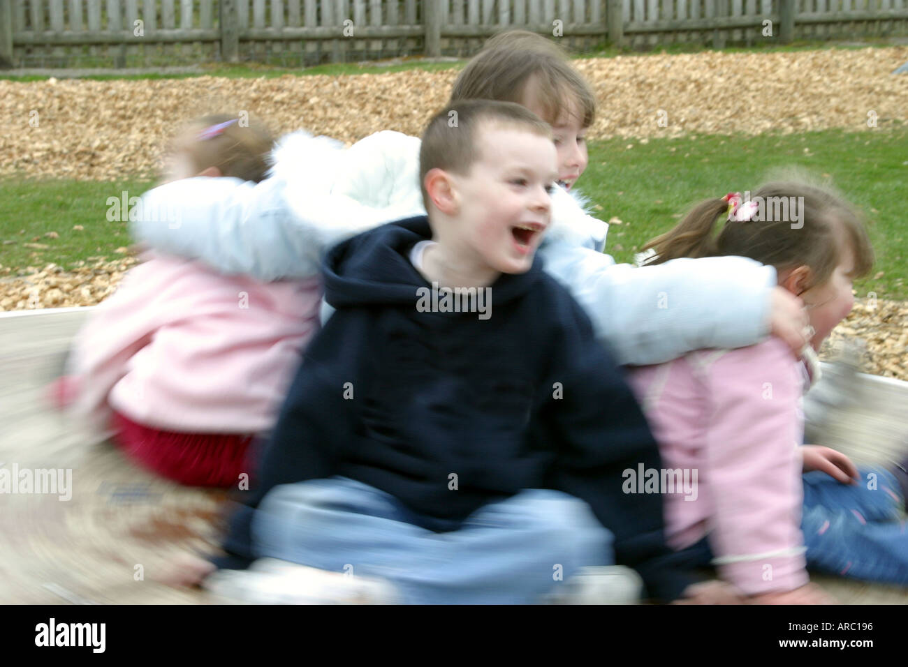 Children spinning on roundabout Stock Photo - Alamy