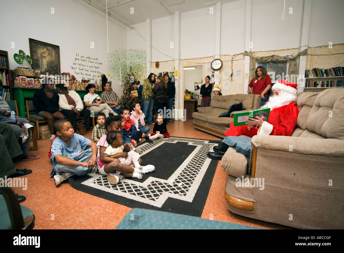 A Santa Claus volunteer reads a Christmas story to local children ...