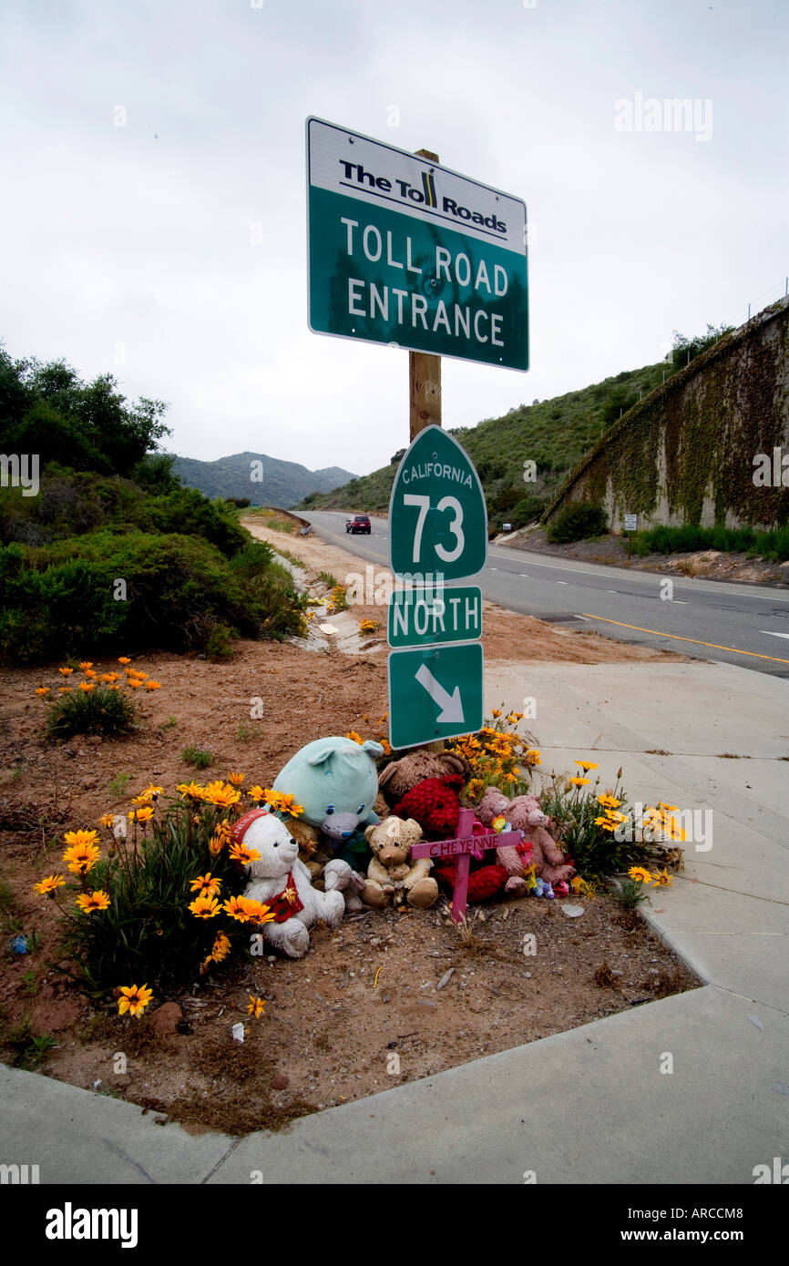 A collection of stuffed toys and a hand made sign at a toll road on ...