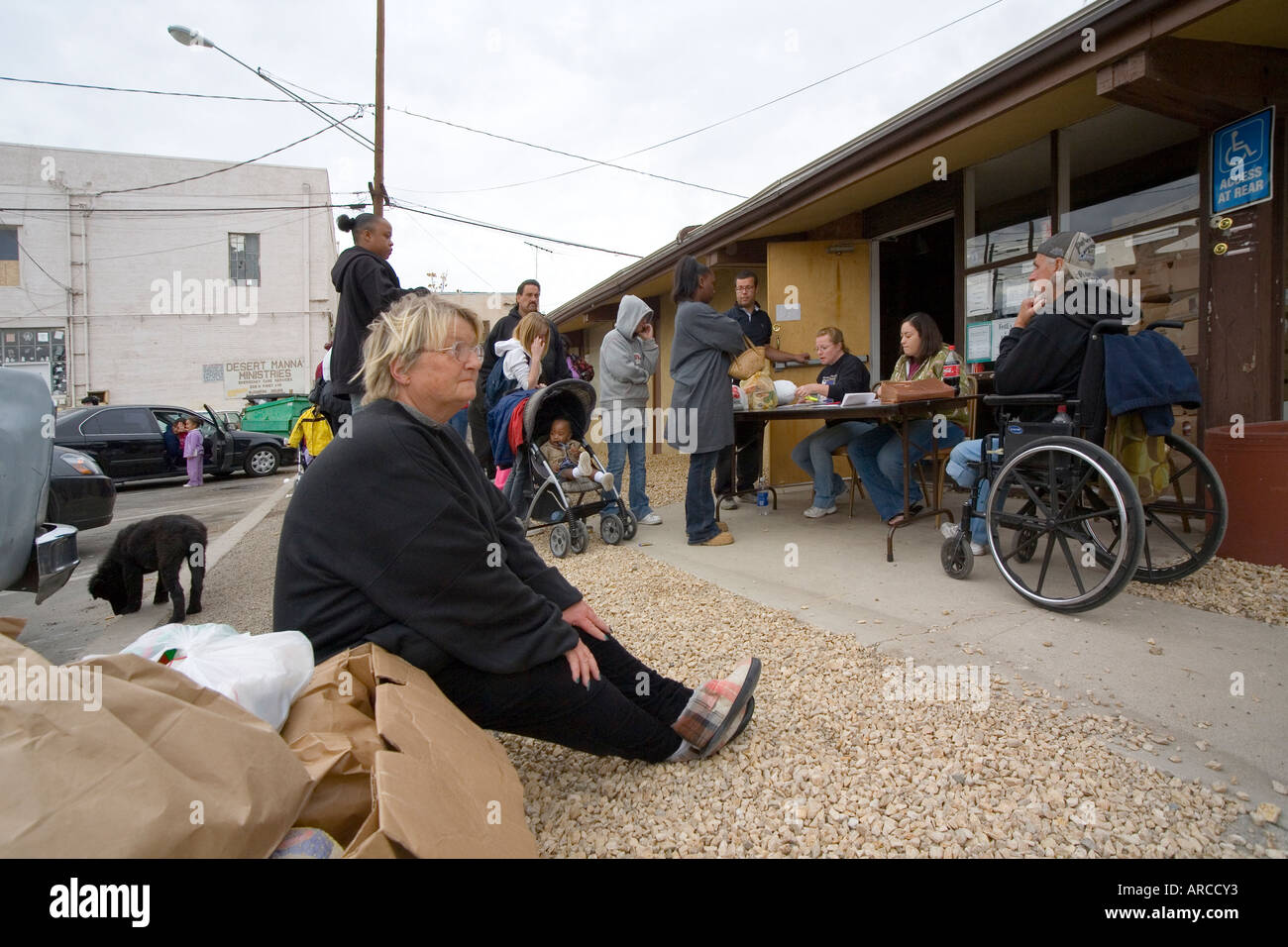 Low income and homeless people line up at a Barstow CA homeless shelter ...