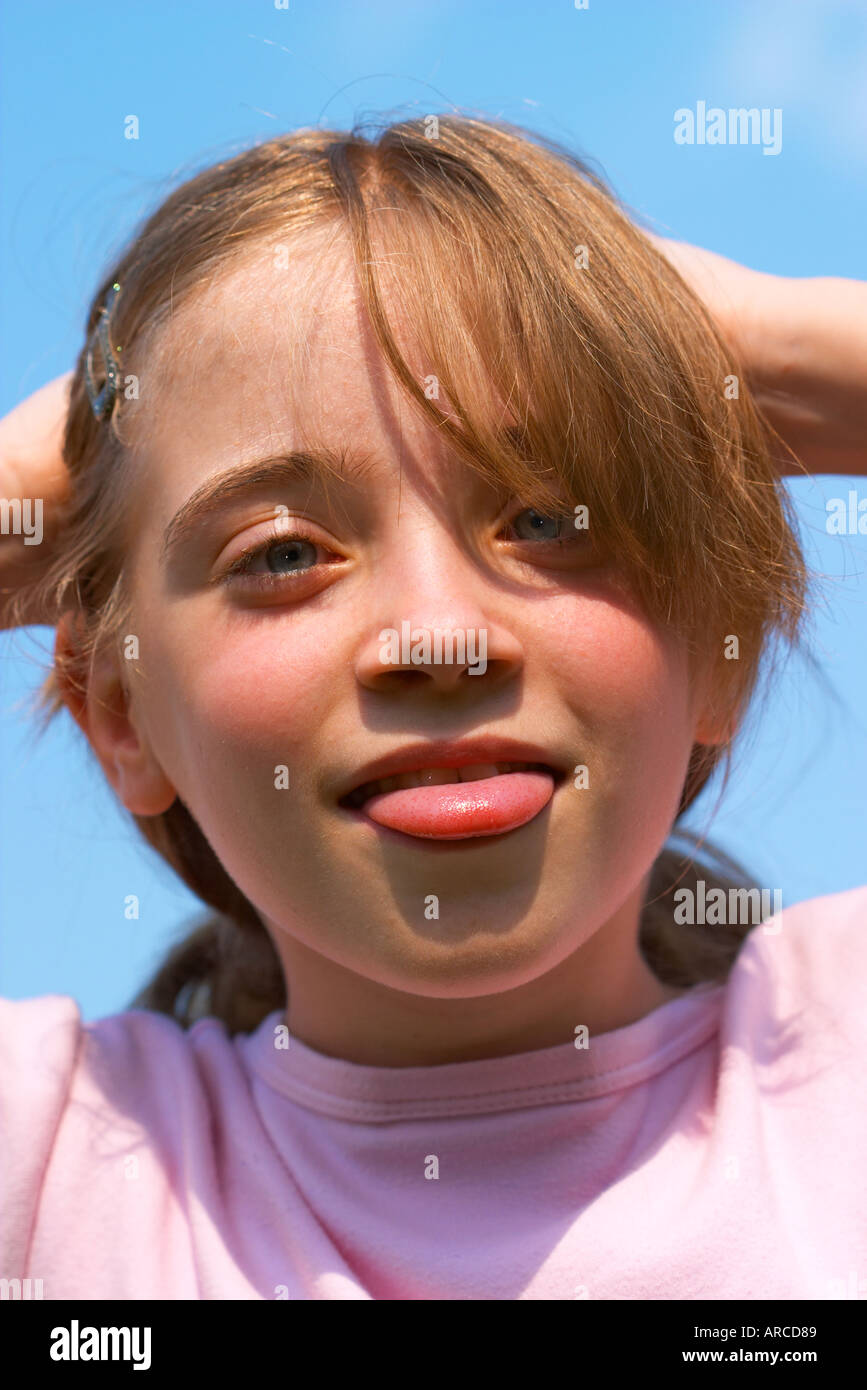 Young girl strikes a silly pose pulling face sticking out tongue Stock ...