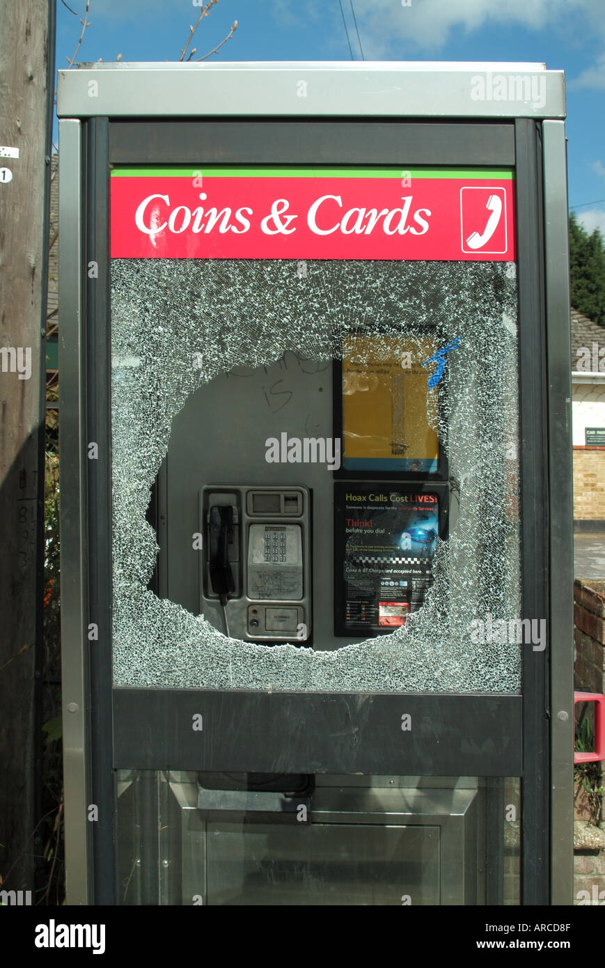 Village payphone call box located outside public house with vandalised ...