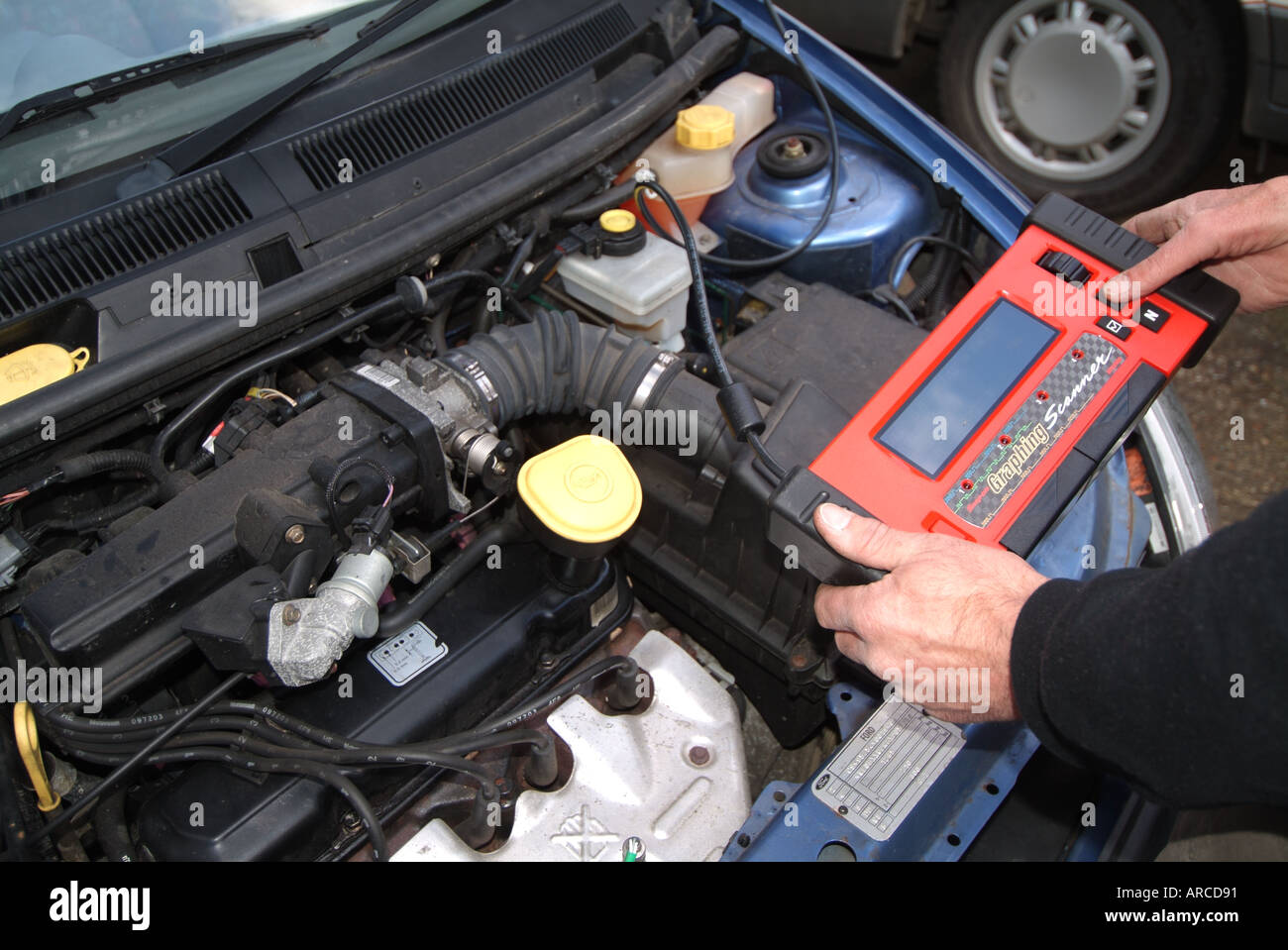 Auto electrician holding an early now historical computerised engine ...