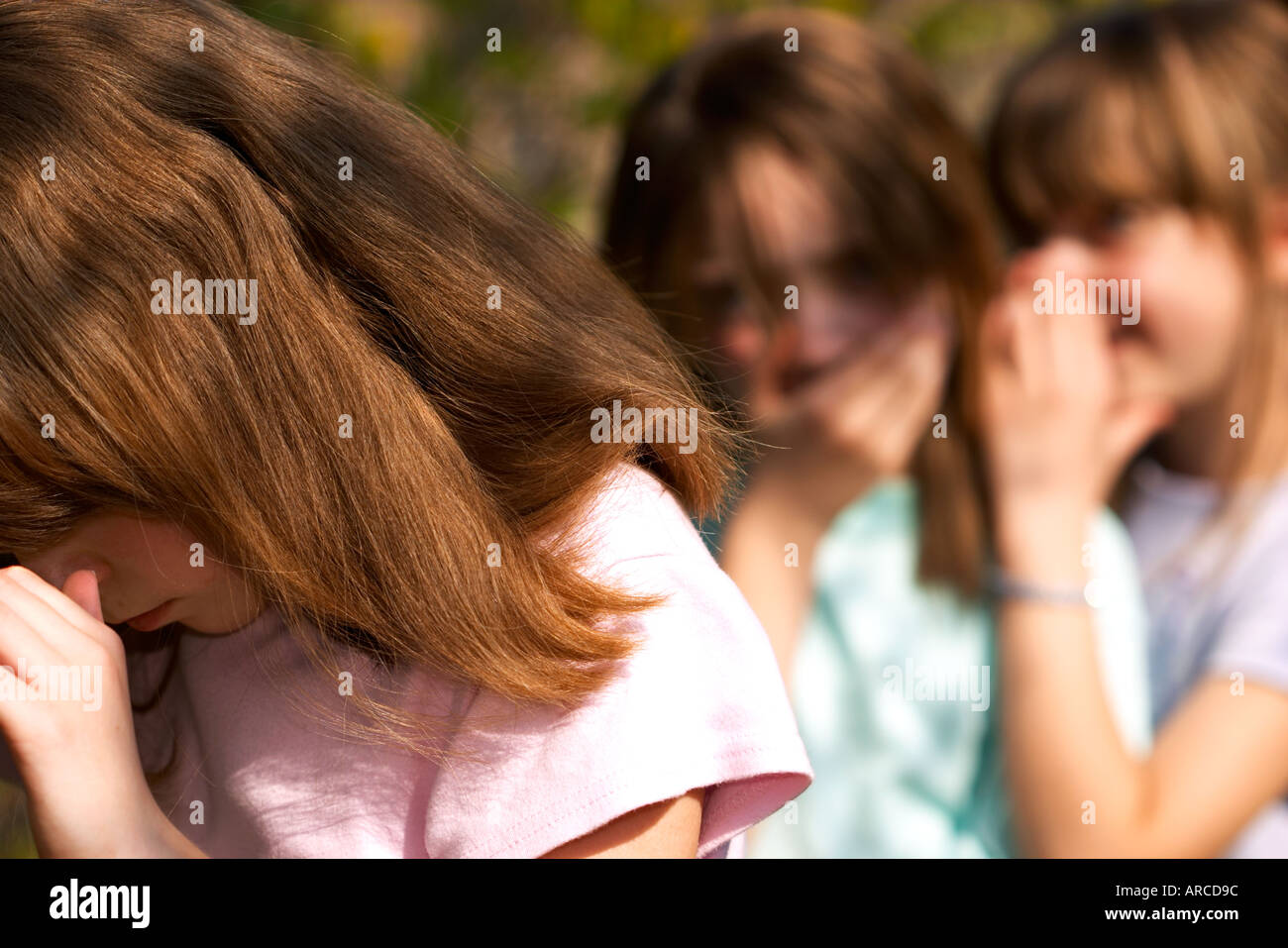 Bullies whisper behind victims back Young bully girls being cruel Stock ...