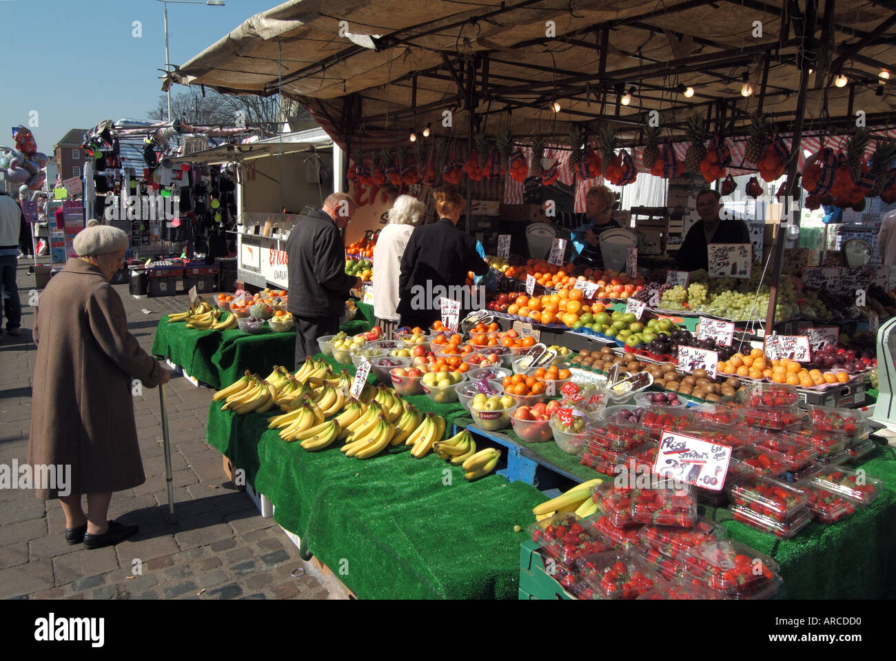 Romford market place with old lady holding walking stick viewing fruit ...