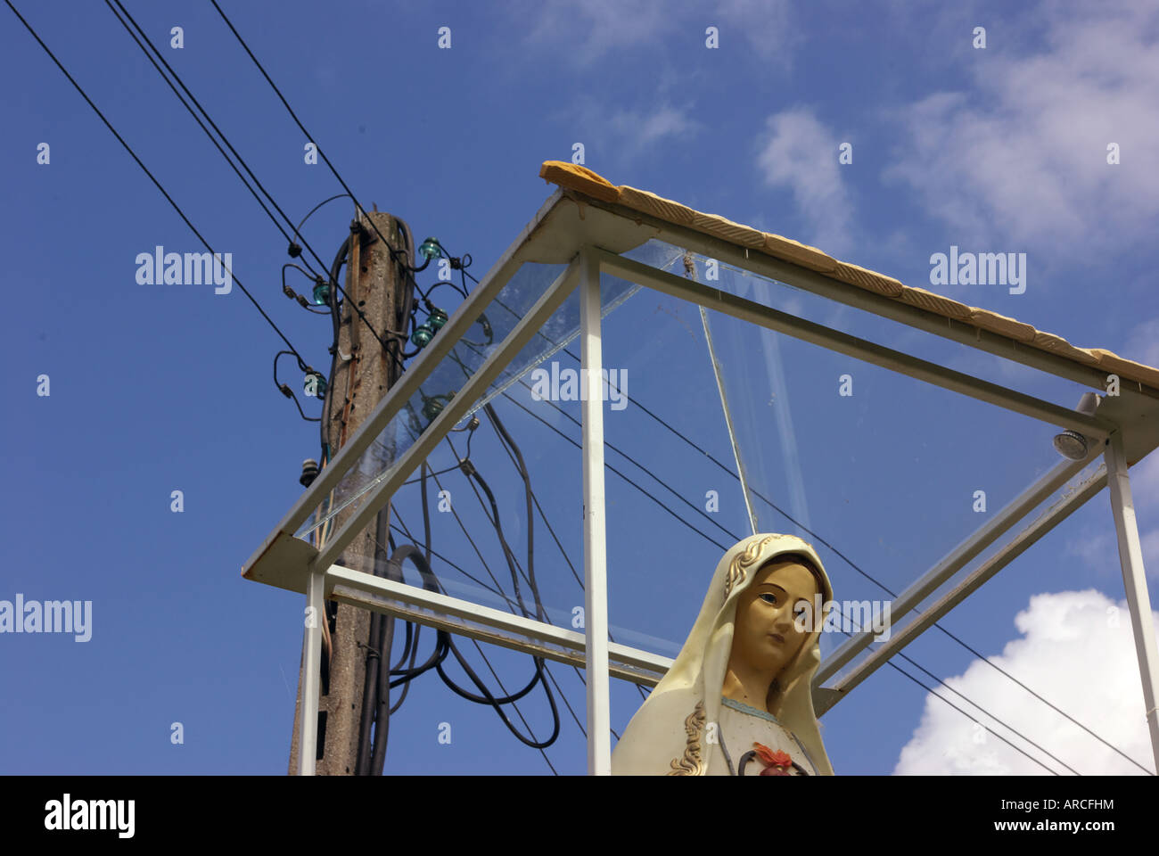 Detail of an outdoor statue of the Virgin Mary in a protective glass ...