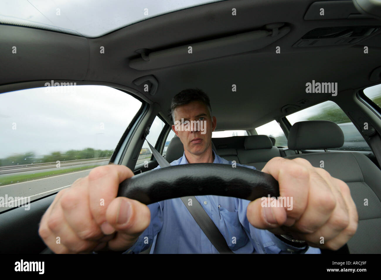 Front view of a man driving a car along UK motorway Stock Photo - Alamy