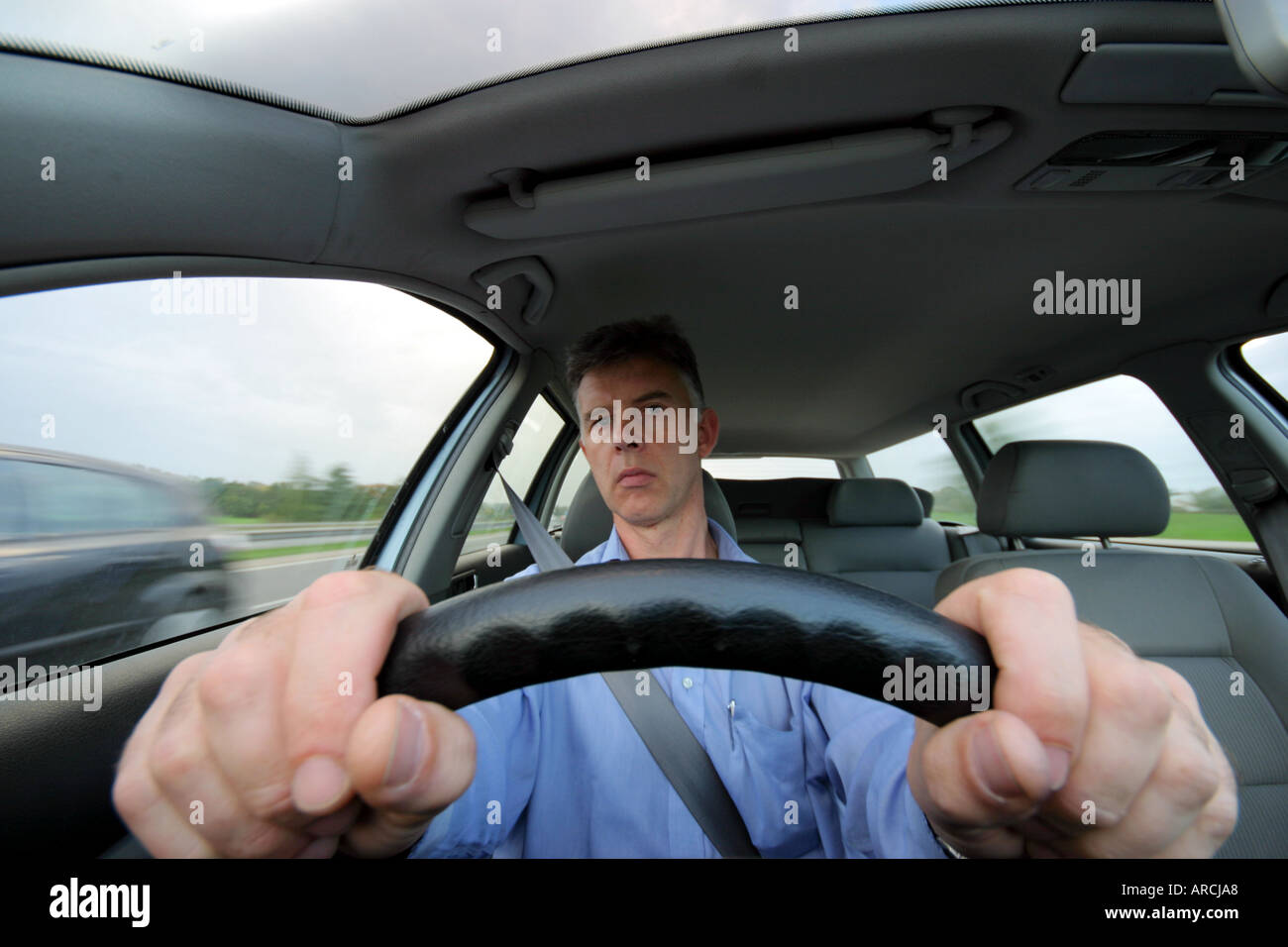 Front view of a man driving a car along UK motorway Stock Photo - Alamy