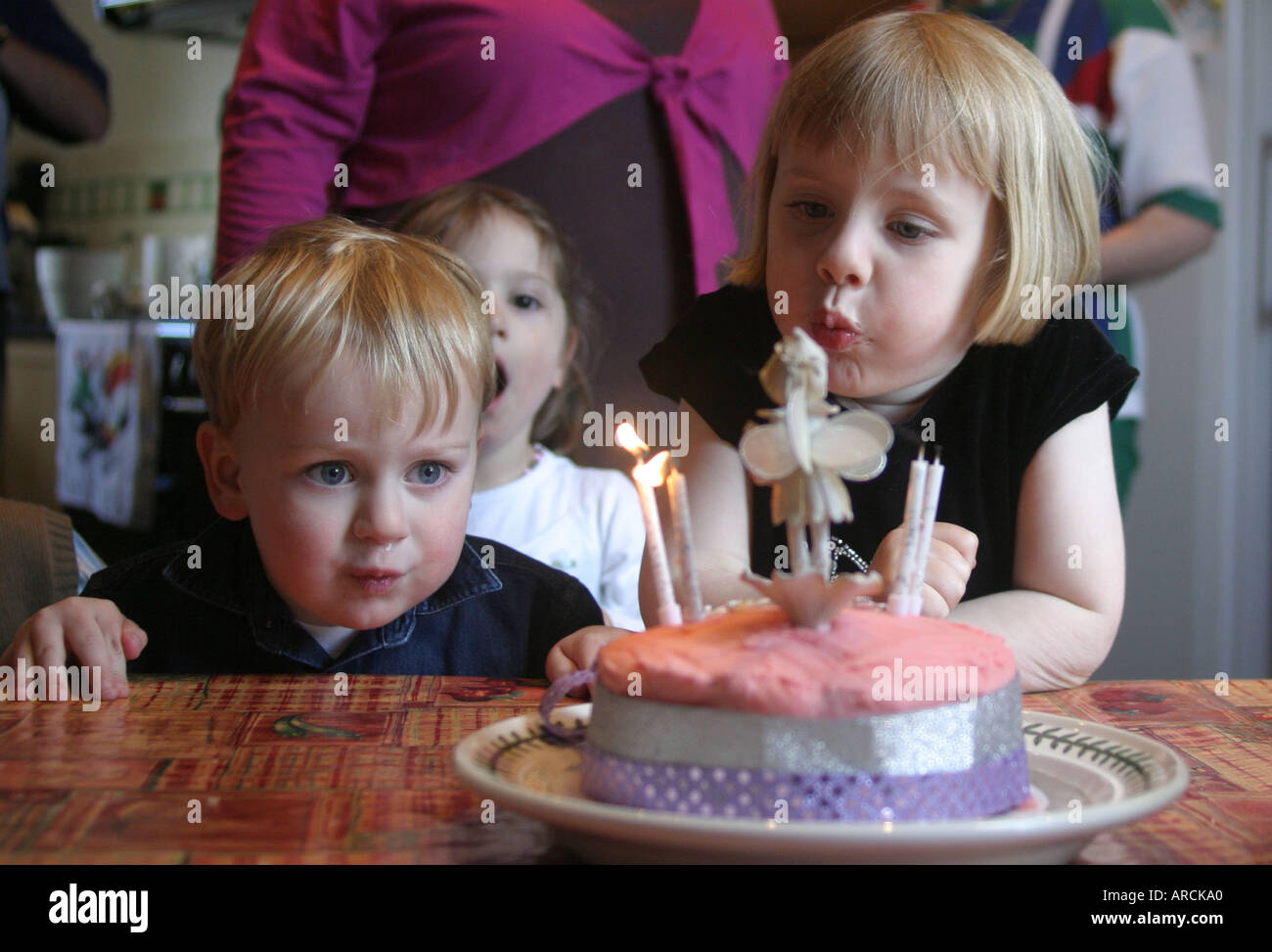 Eve blows out the candles on her 4th birthday cake Stock Photo - Alamy