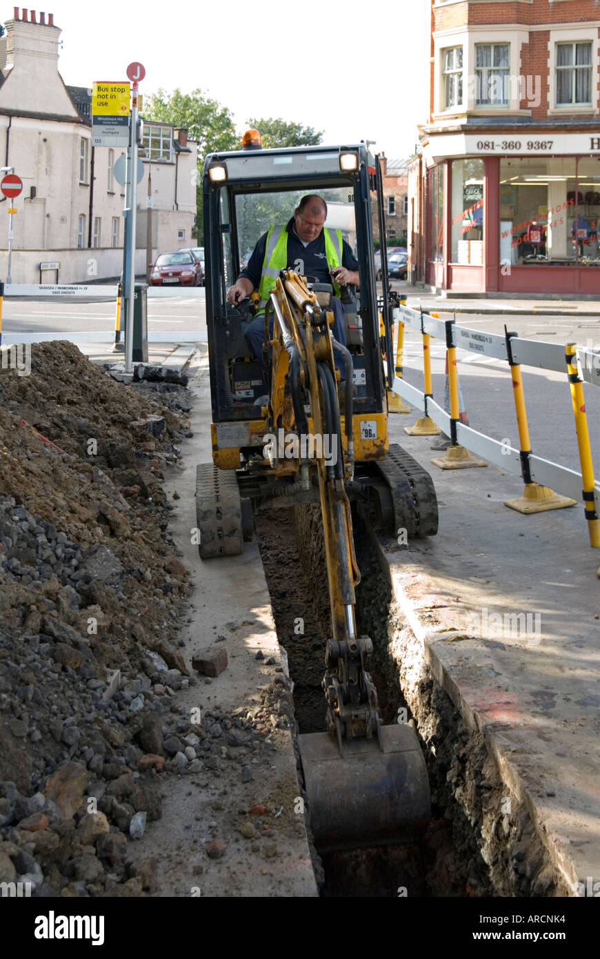 Digging roadside trench using a mechanical digger Stock Photo - Alamy