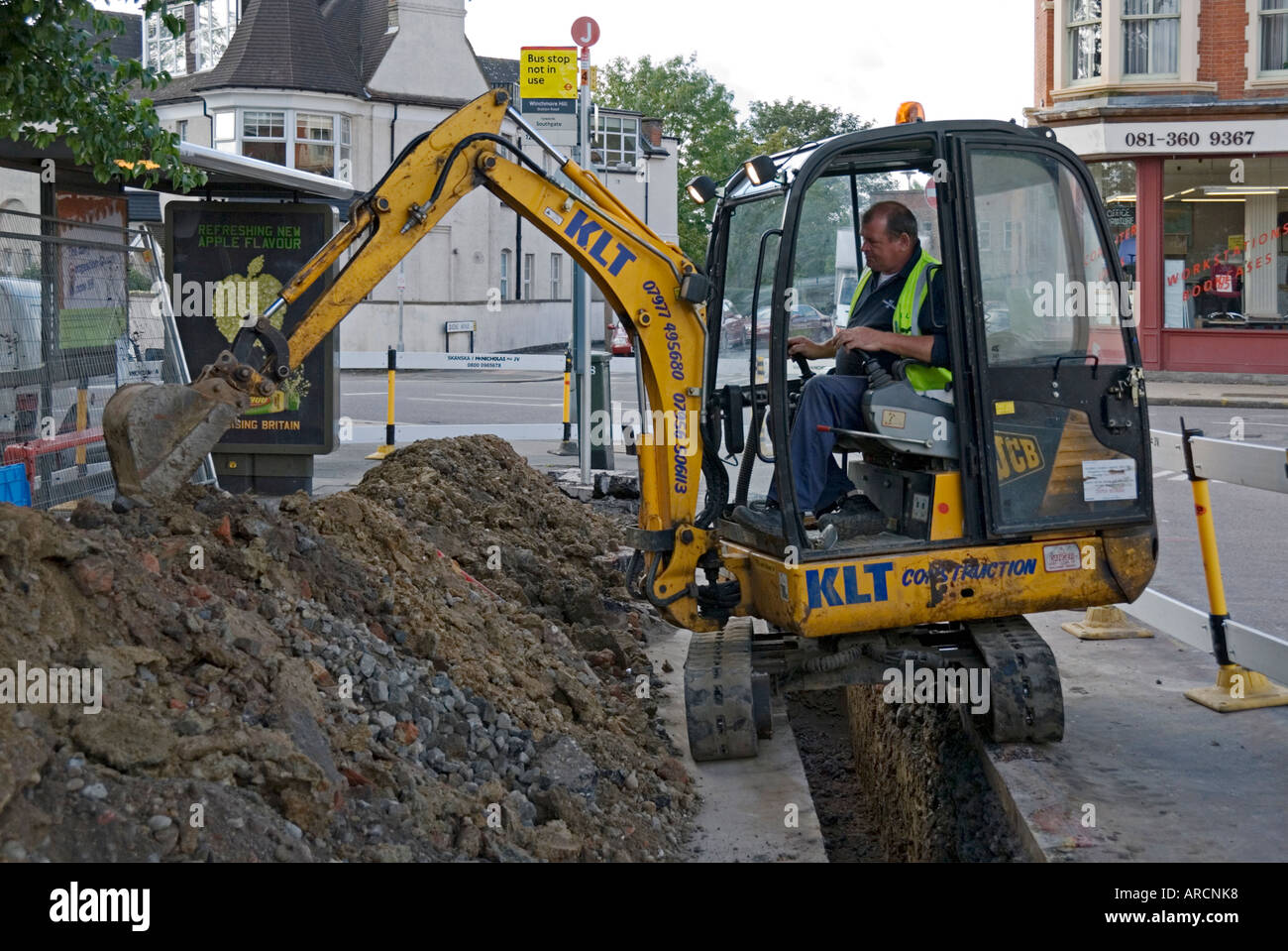 Digging a roadside trench using a mechanical digger Stock Photo - Alamy