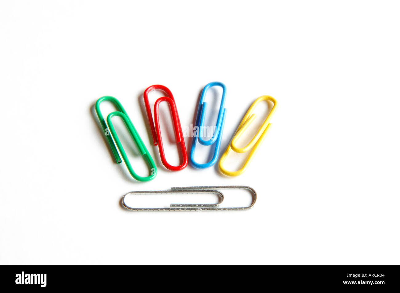 Colourful red, green, yellow and blue paperclips arranged with plain ...