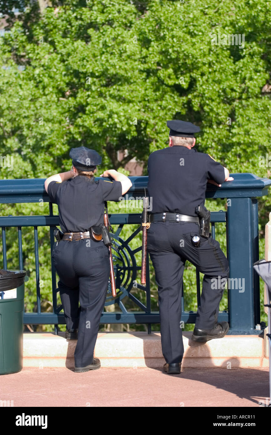 Male and female police leaning on a railing looking out at the view ...
