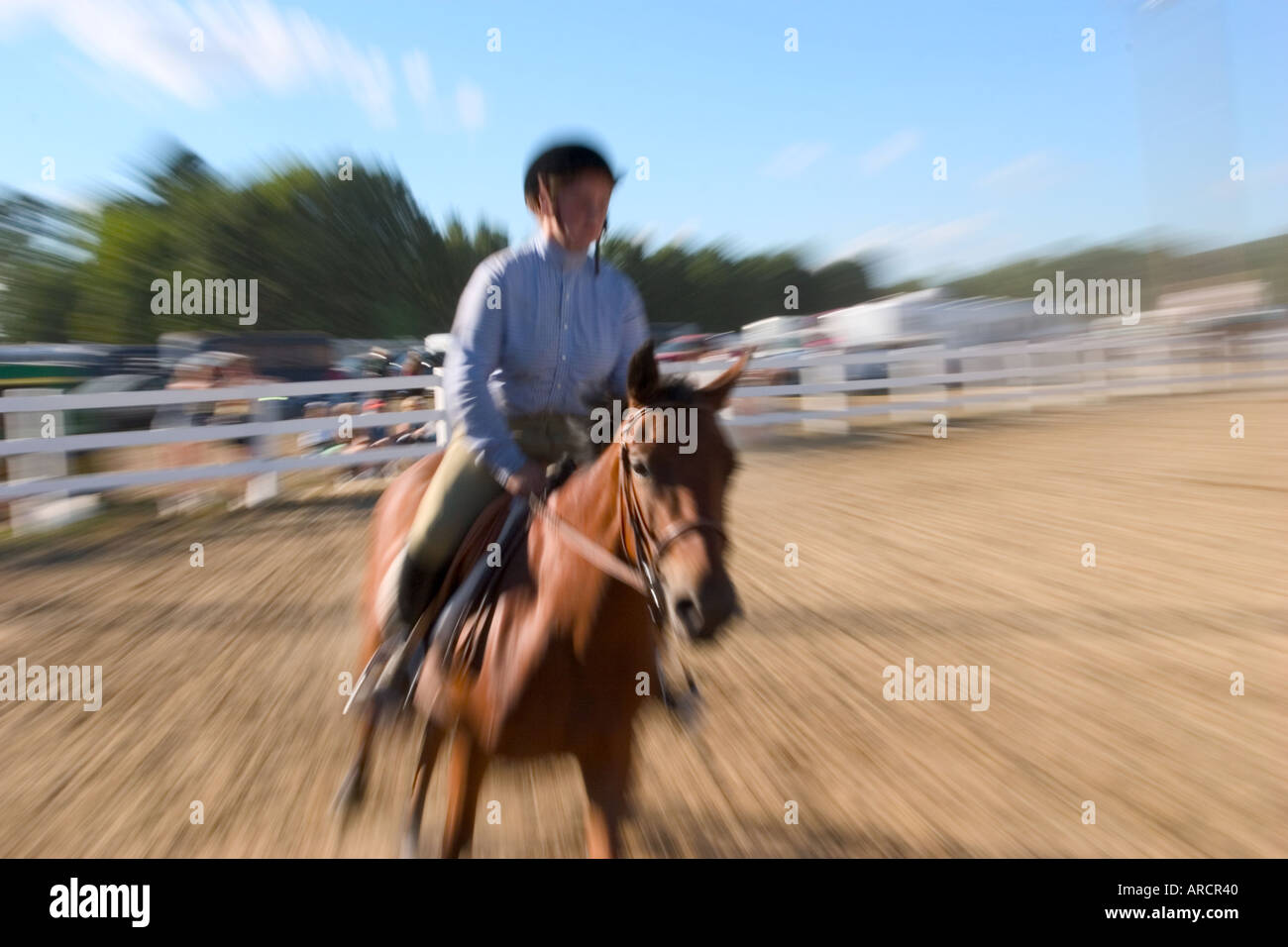 Teen girl wearing a helmet and riding clothes riding her horse in a ...