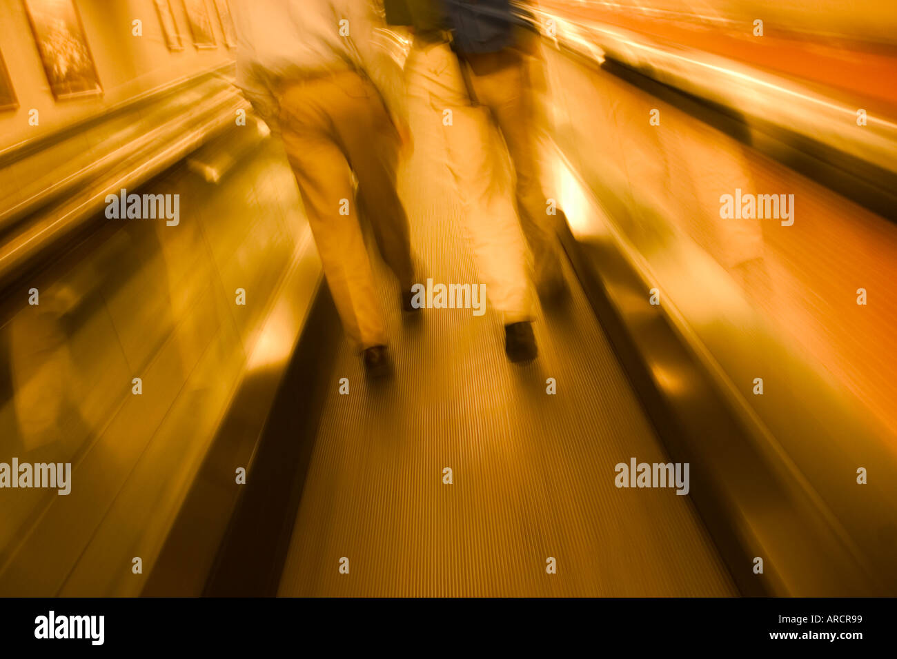 Two men on a moving walkway in an office building Stock Photo - Alamy