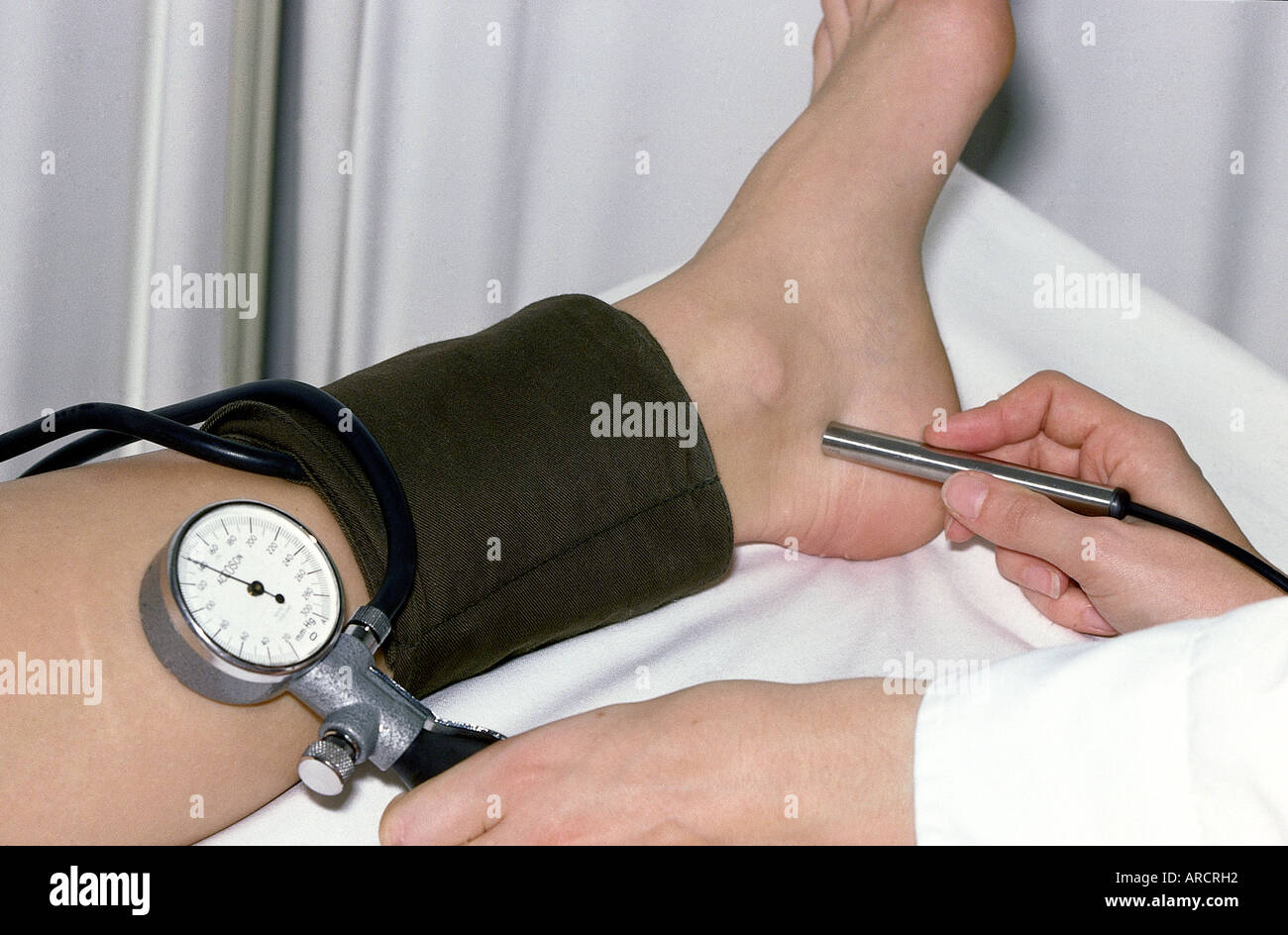 A photograph of a doctor performing blood flow studies using a handheld ...