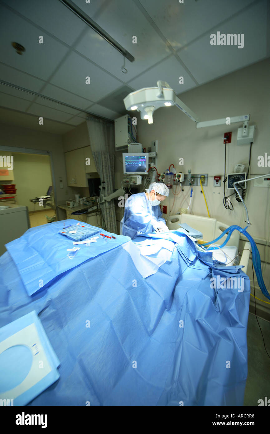 A female surgical resident in the intensive care unit (ICU) inserting a ...