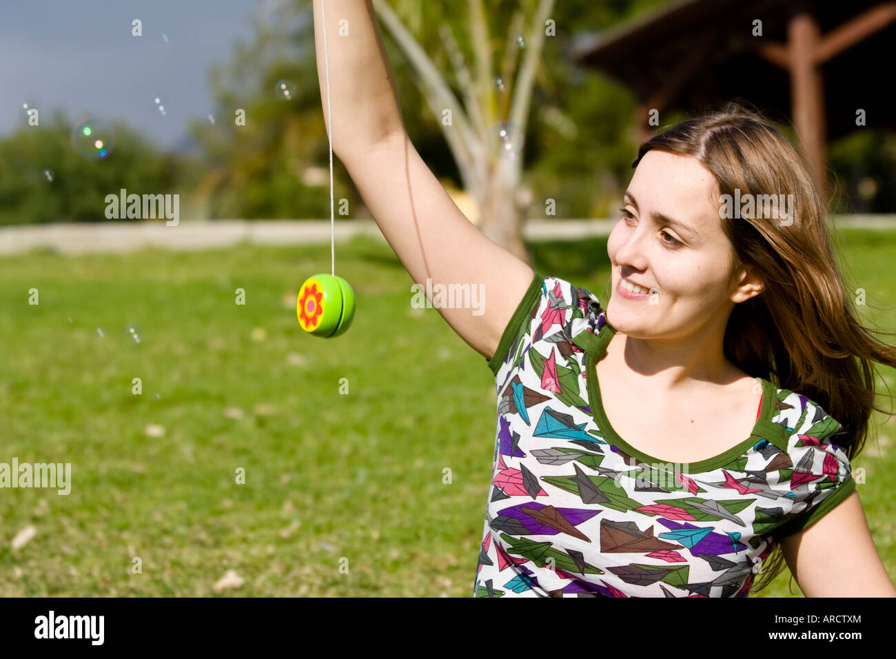 Young woman playing yo yo in the park Stock Photo - Alamy