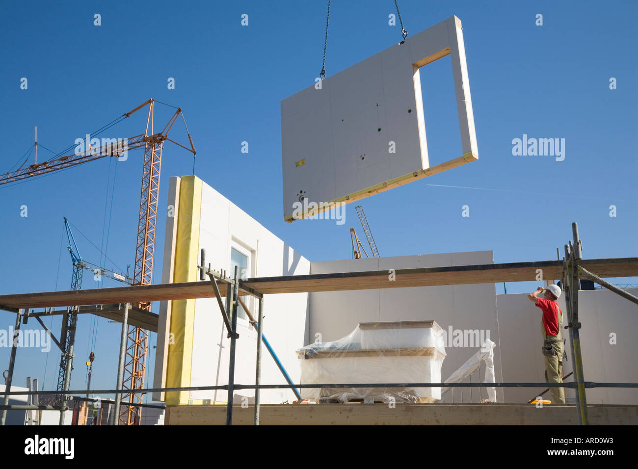 Construction workers building a prefabricated house in a new ...