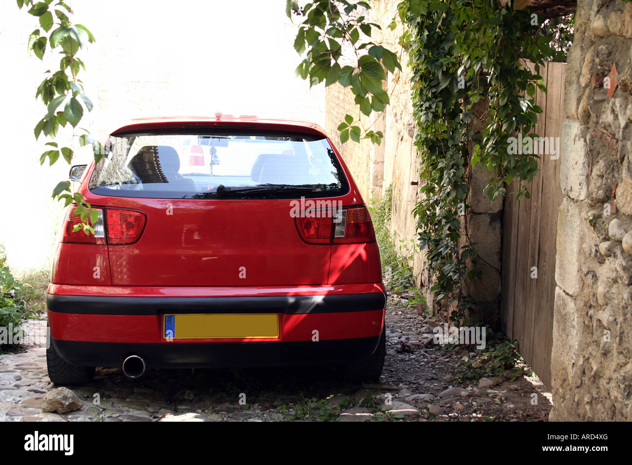 red car parked near a stone wall Stock Photo - Alamy