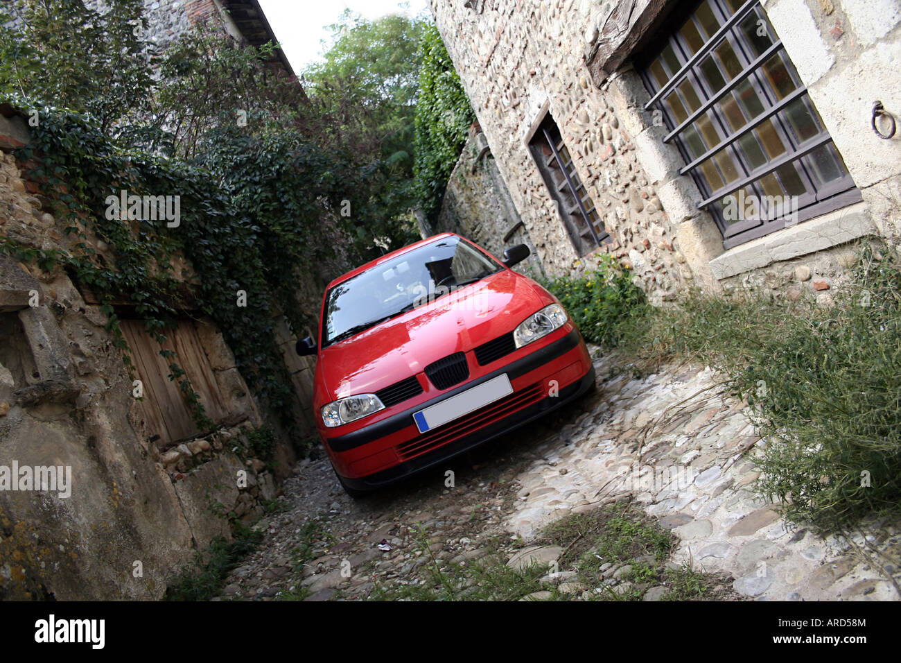 red car parked near a stone wall Stock Photo - Alamy