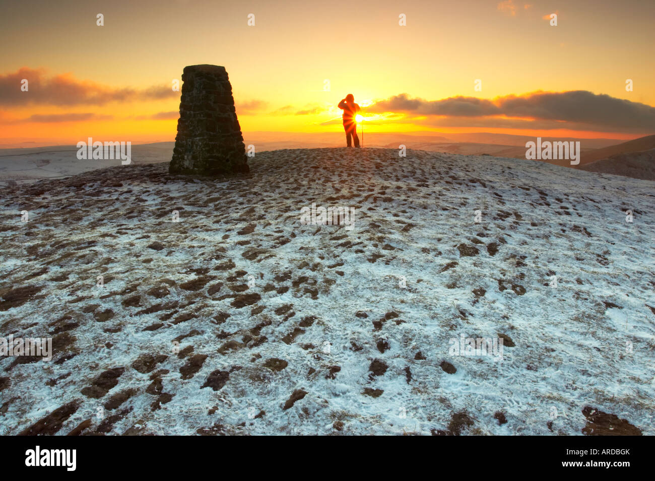 A lone hiker watches the sunset from the top of Mam Tor in Derbyshires ...