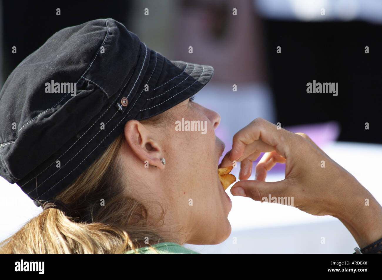 Woman with hat is eating someting Stock Photo - Alamy