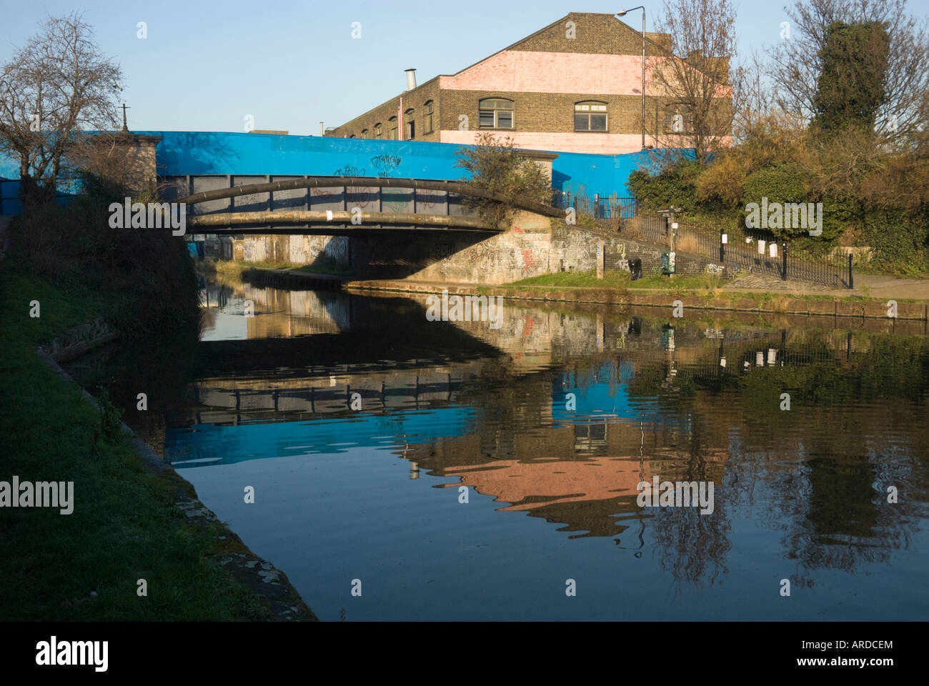 The blue fence surrounding the London Olympic site goes across the Lea ...