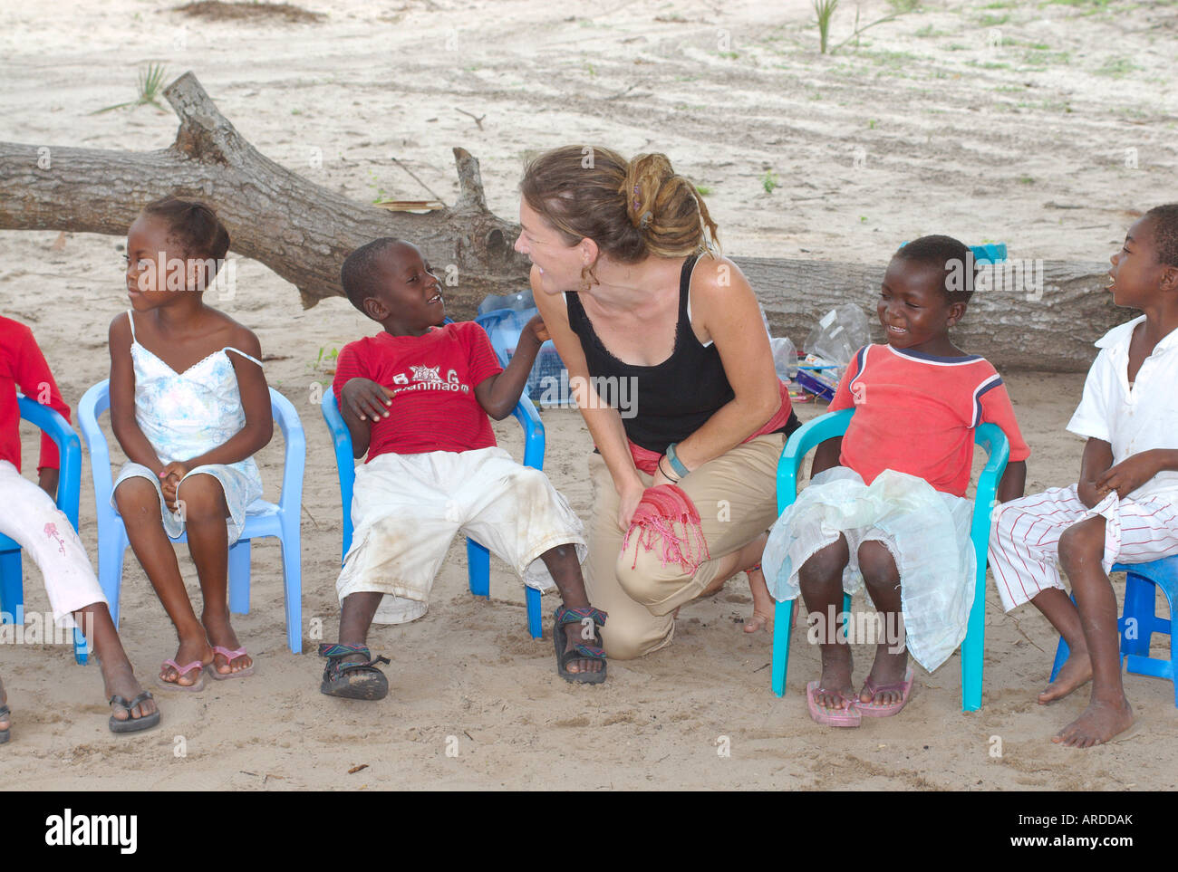 Volunteer teachers educate a class of Mozambican children in a bush ...