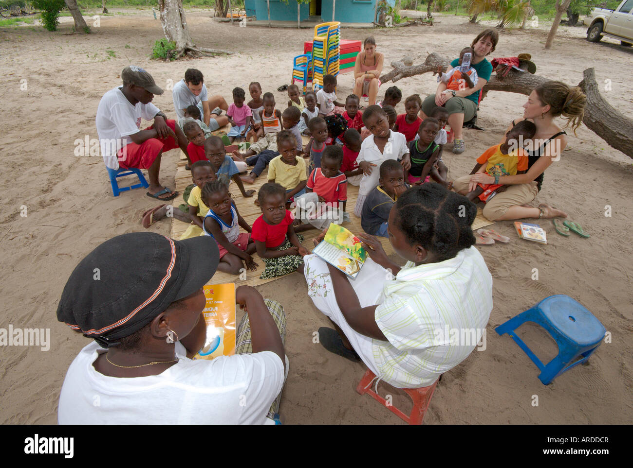 Volunteer teachers educate a class of Mozambican children in a bush ...
