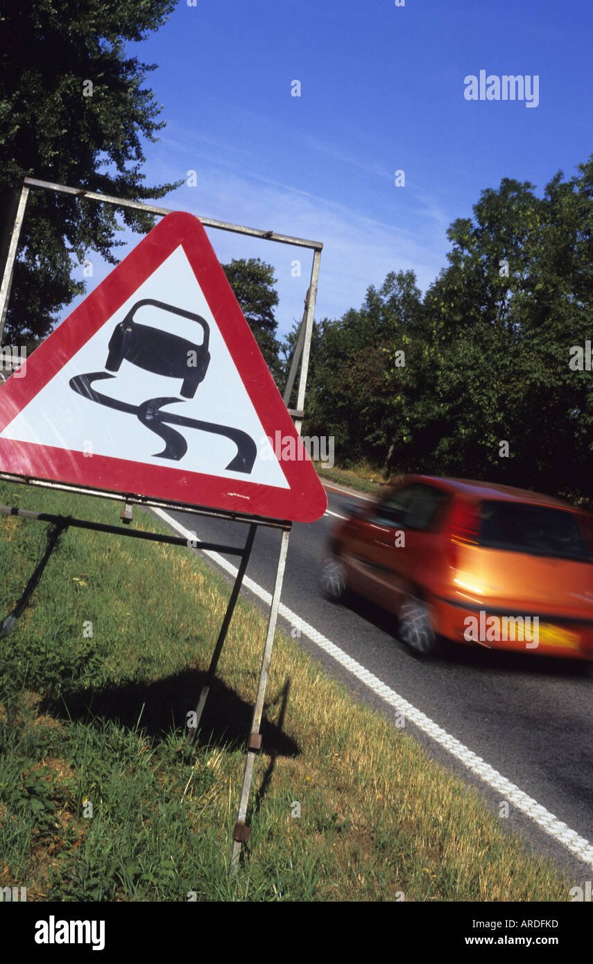 car passing slippery road surface warning sign leeds uk Stock Photo - Alamy