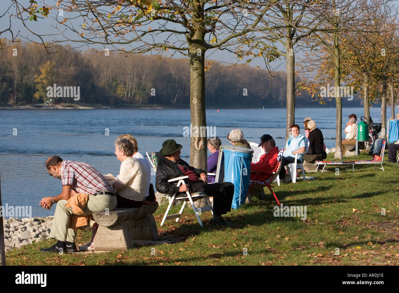 People relaxing on the banks of the River Rhein near Karlsruhe Germany ...