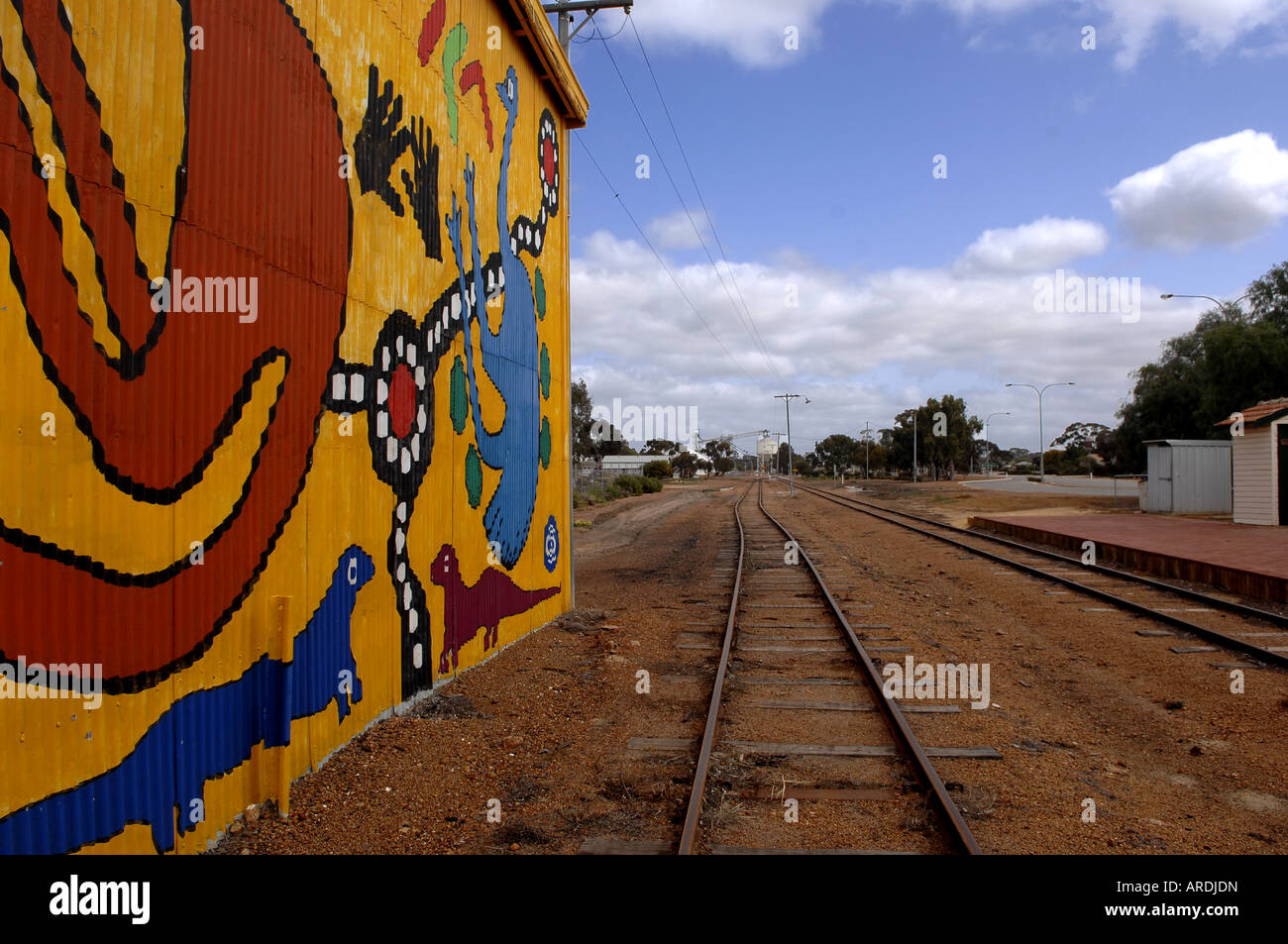 Aboriginal art decorates the side of a shed by a railway in the ...