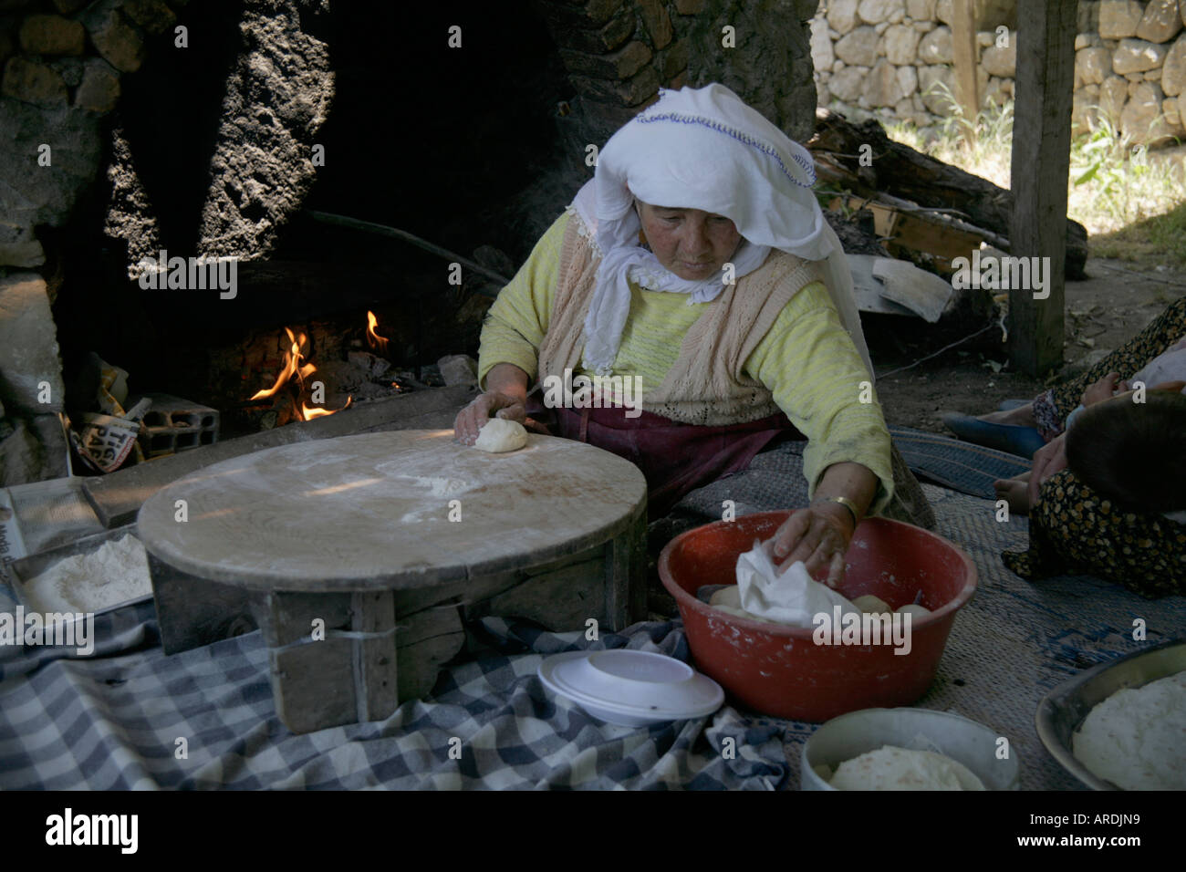 Old turkish woman bakes pitta bread in traditional fire oven Stock ...