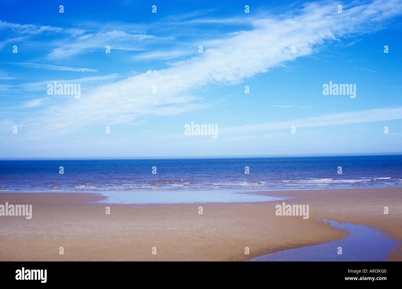 View of wide empty sandy beach with some patches of still lying ...