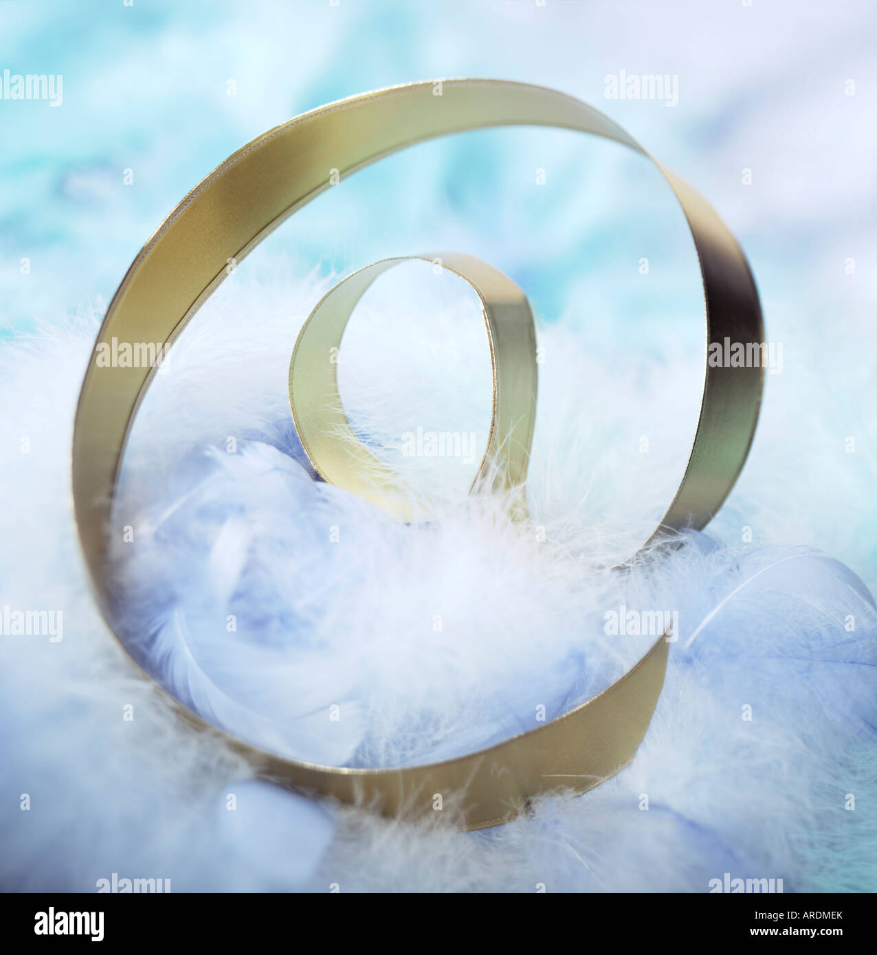 Gold "at" symbol in blue feathers Stock Photo - Alamy