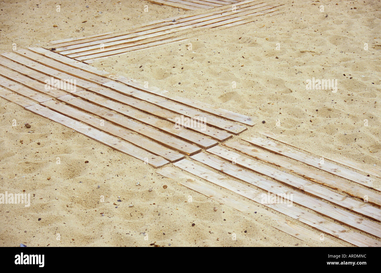 Part of a boardwalk zig-zagging across soft dry white powdery sand ...
