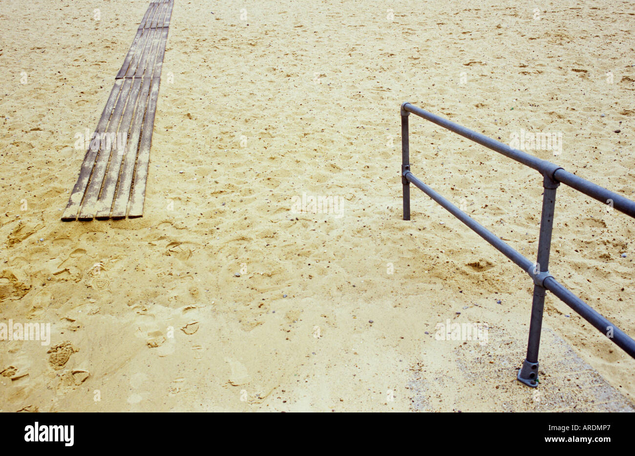 Foot of concrete ramp with railing as it lowers into soft white dry ...