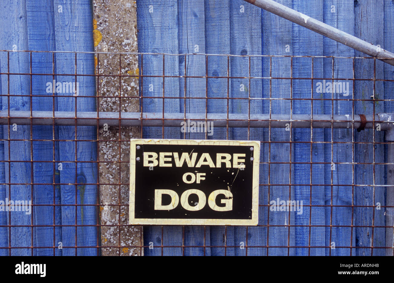Aluminium pole and wire mesh gate opened back onto timber and concrete ...