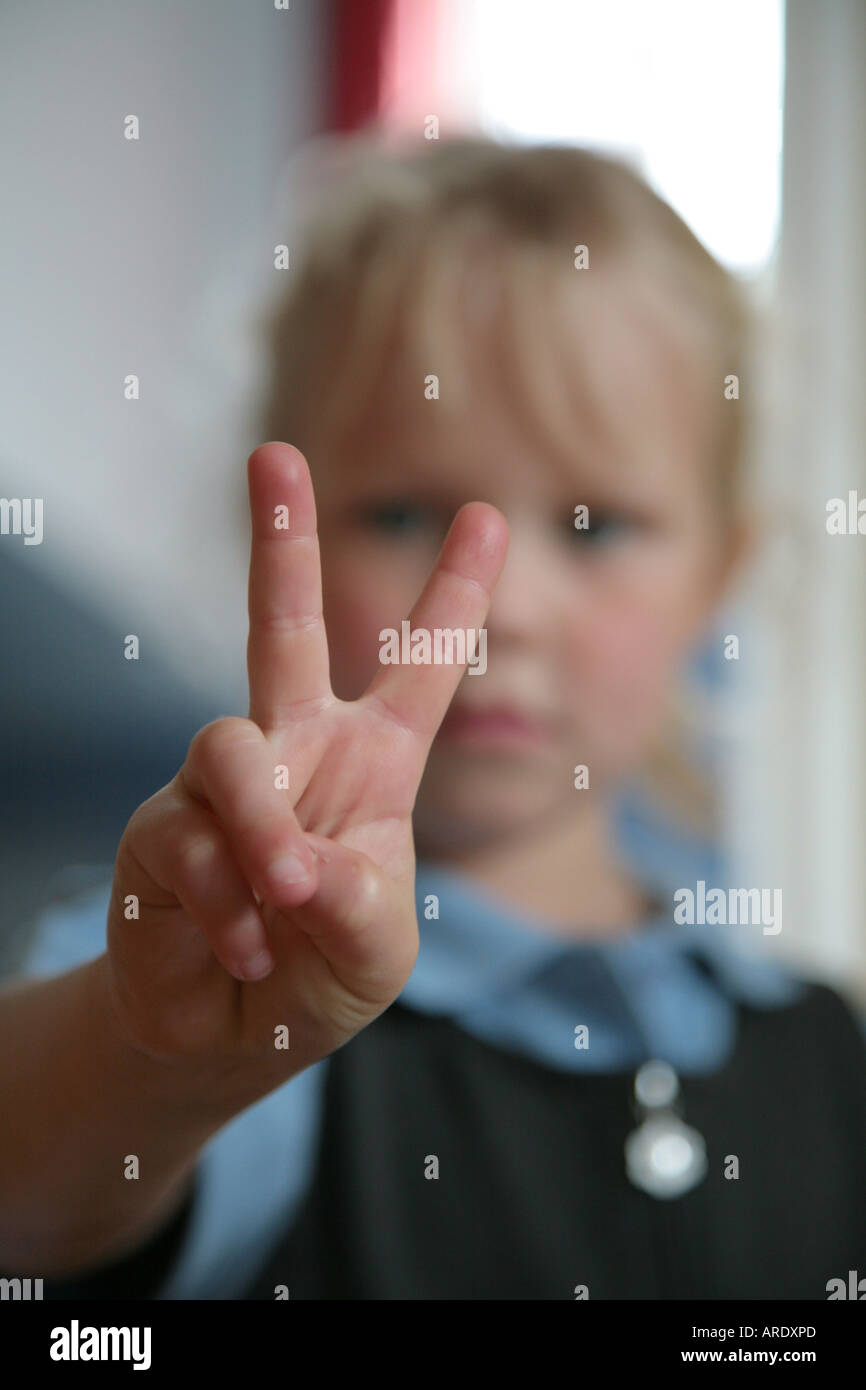 young girl making peace sign Stock Photo - Alamy