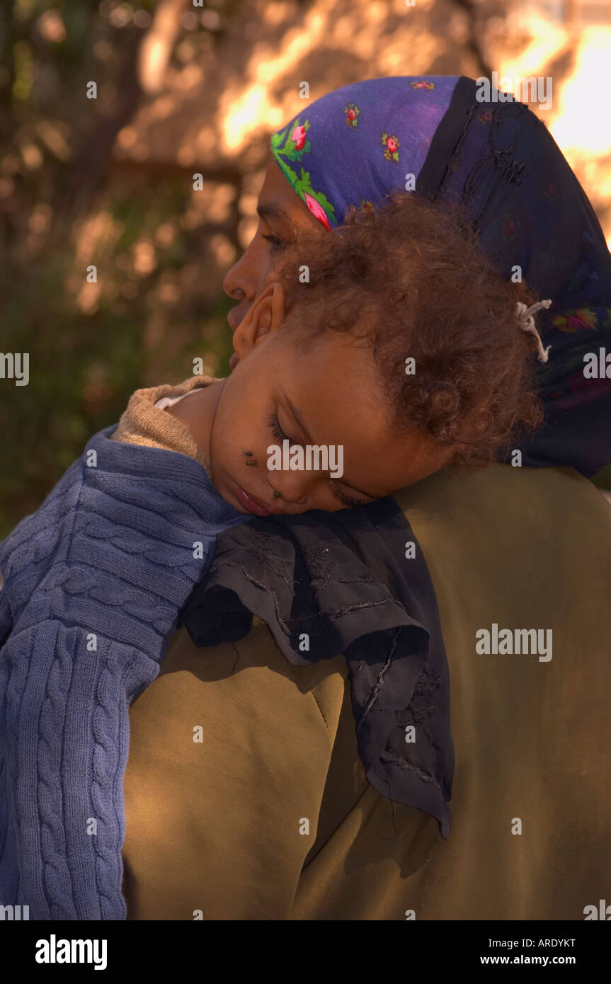 Egyptian woman carrying sleeping child Stock Photo - Alamy