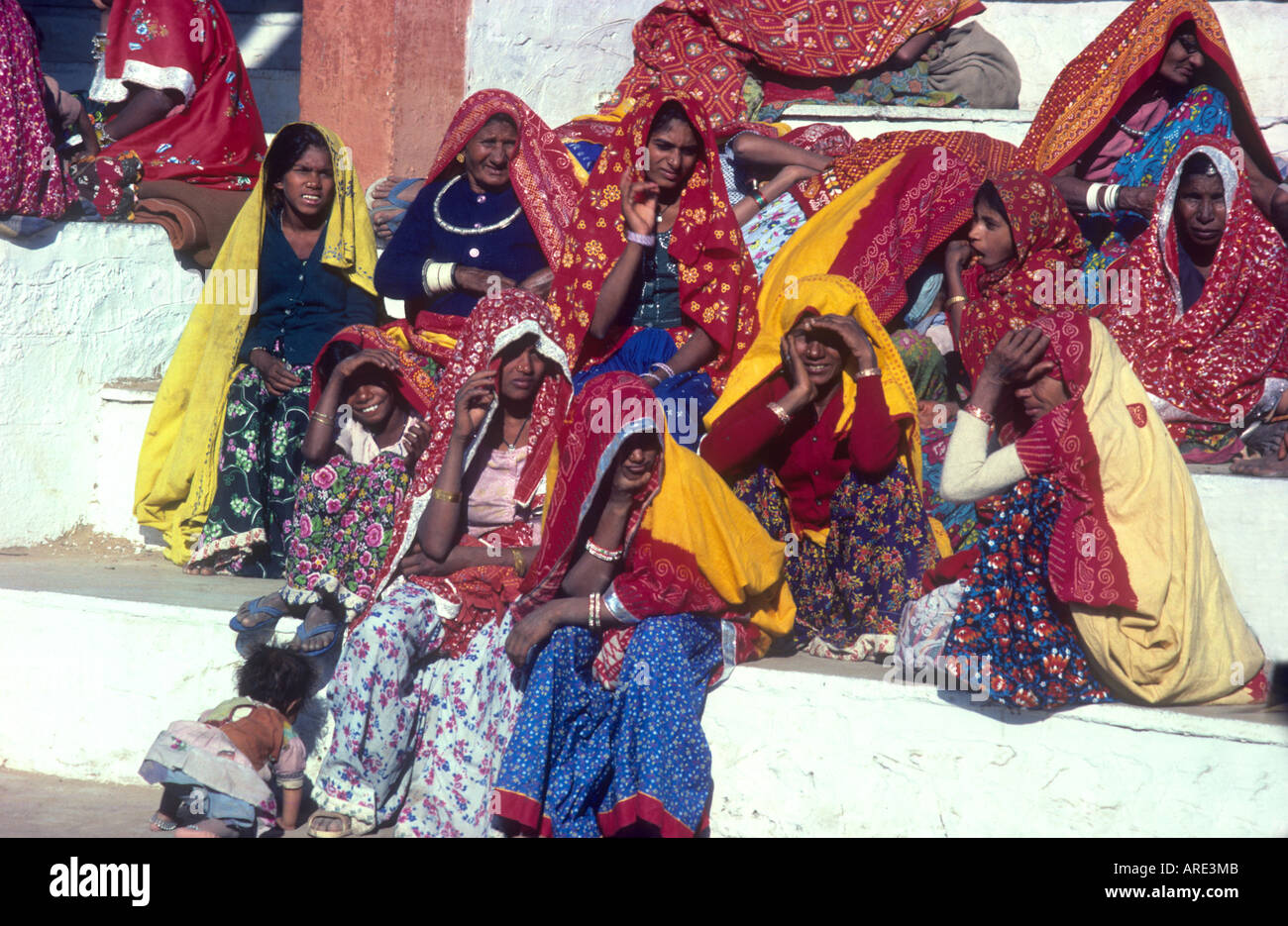 Brightly attired desert tribeswomen waitng for camel races at annual ...