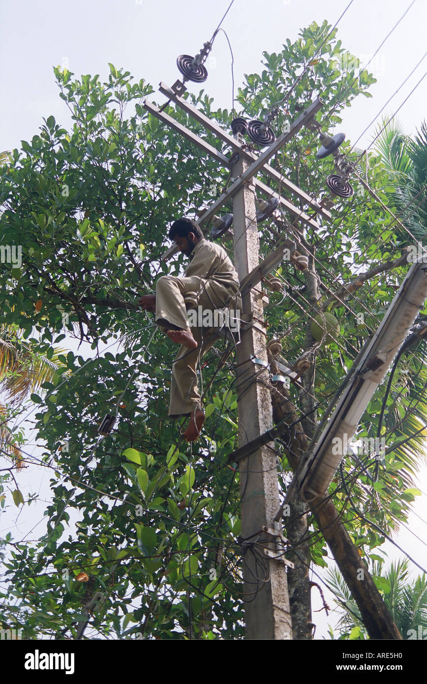 local electrician fixing the electric line on a makeshift pole India ...