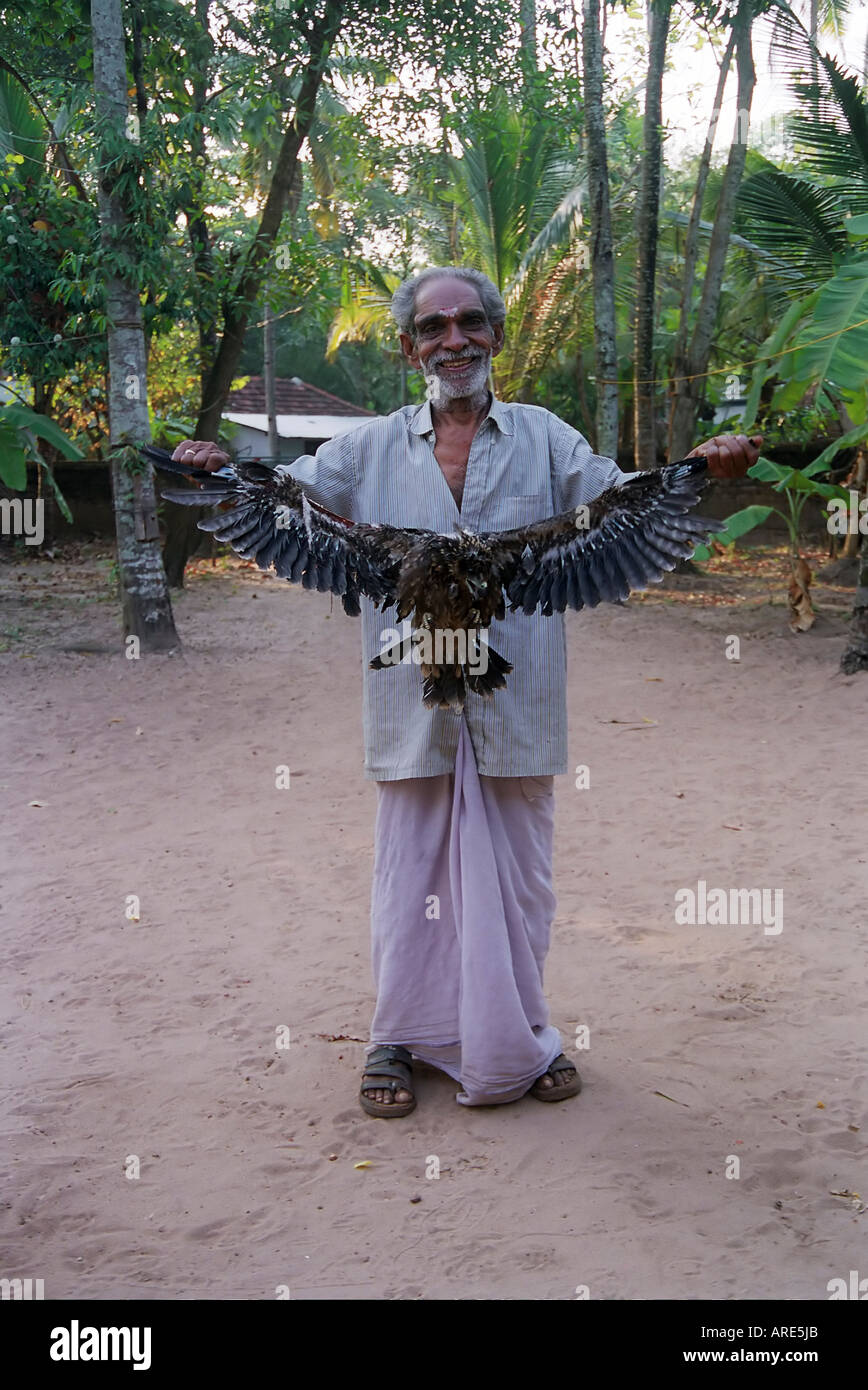 a man showing the wing span of his hawk India Kerala a state on the ...