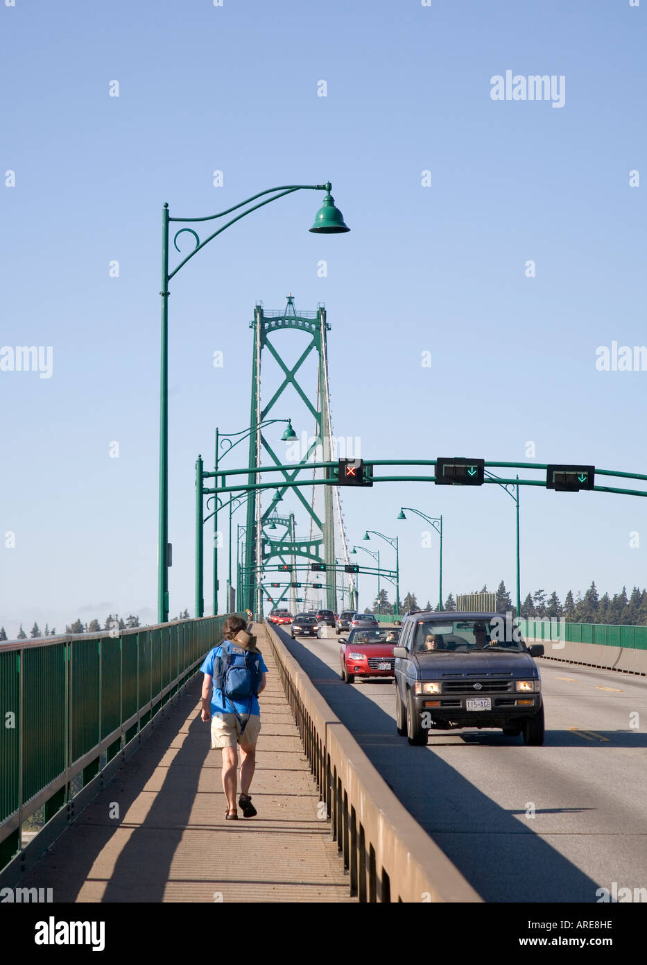 Pedestrian walking over Lions Gate suspension bridge with oncoming ...