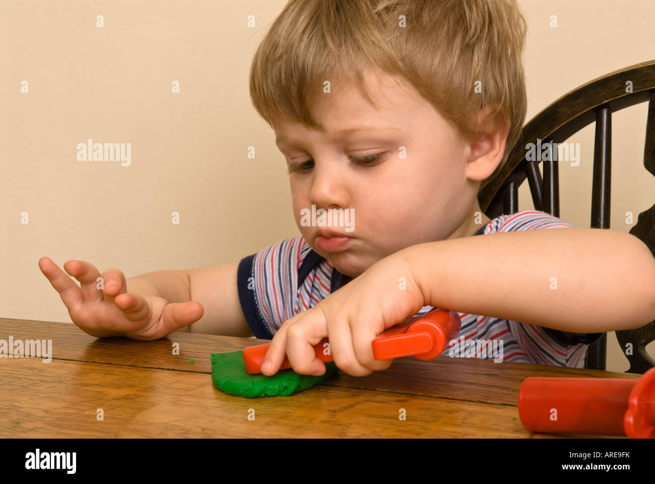 boy toddler child playing with 'Play Dough' tools and toys cutting and ...
