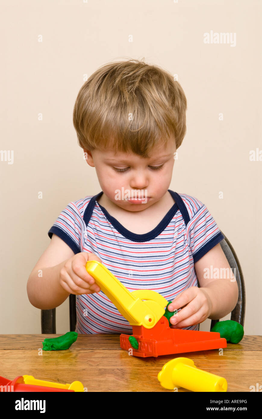 boy toddler child playing with 'Play Dough' tools and toys cutting and ...